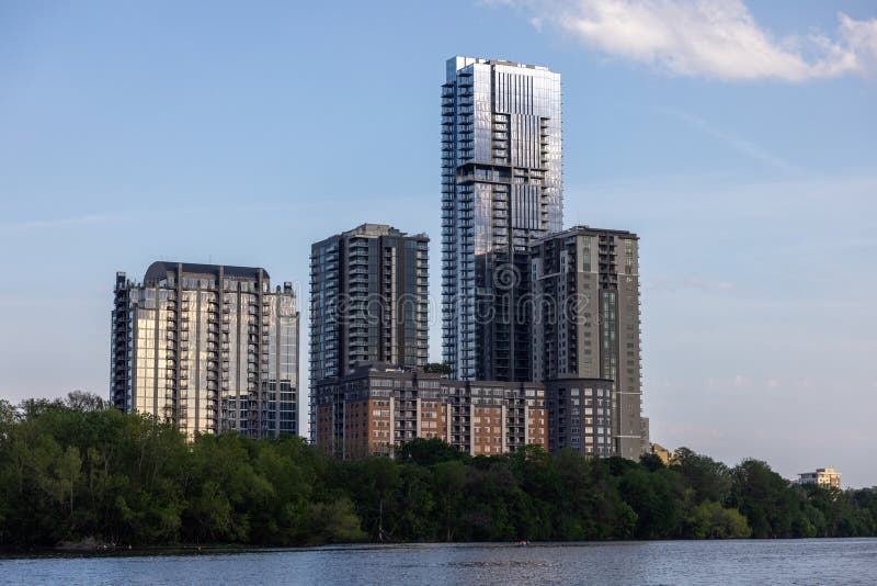 Of Several Tall Buildings in the Distance Behind the Water and Trees ...