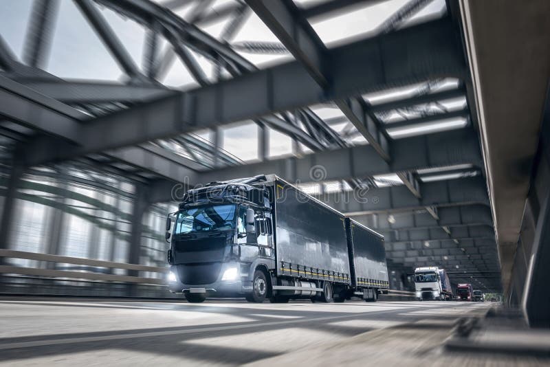 Several Trucks Driving Over a Bridge in an Industrial Area Stock Photo ...