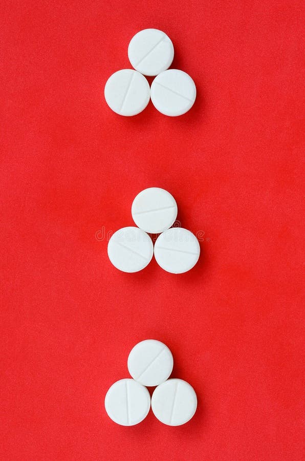 Several White Tablets Lie on a Bright Red Background in the Form of ...