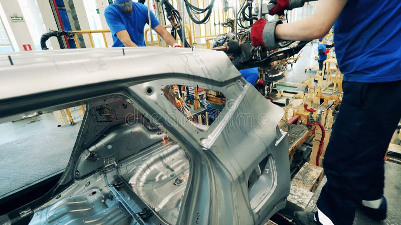 Car Workers Using Welding Machines To Weld Car Body Parts Stock Video ...