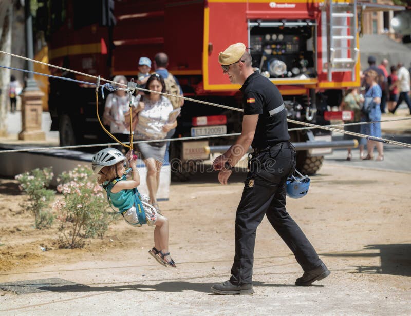 Emergency Unit Instructor Assisting Kid in Zip Line during Display of ...