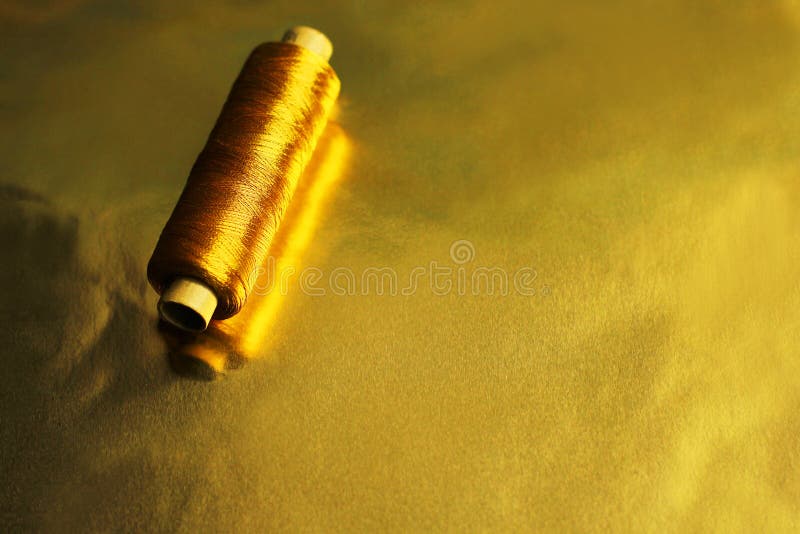 Sewing Threads on a Gold Background. Bright Shiny Threads. Gold and ...