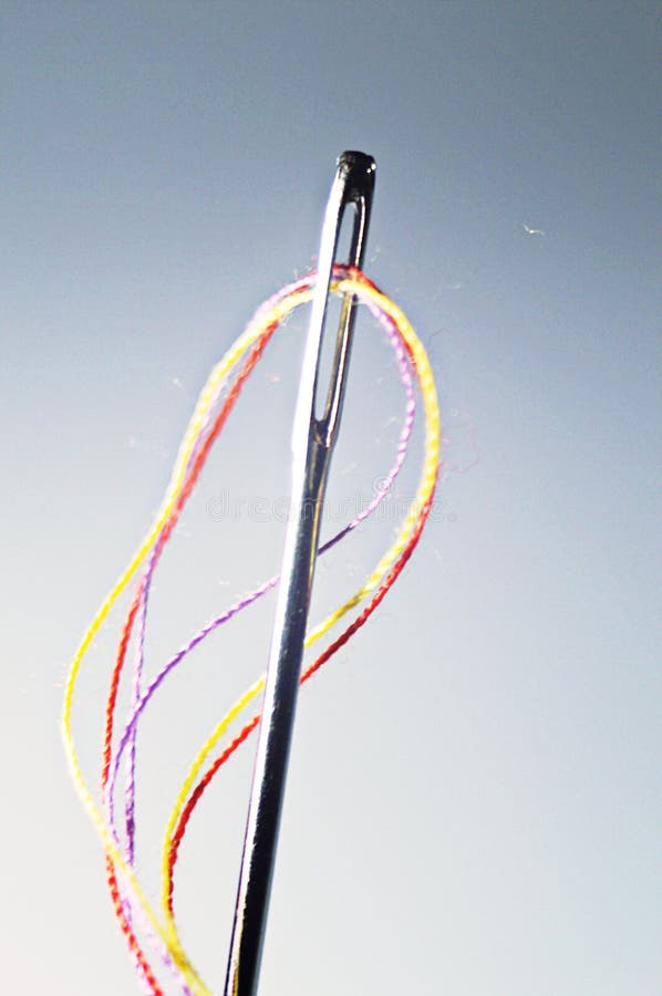 Sewing Needle with Threaded Colored Threads on a Light Background Stock ...