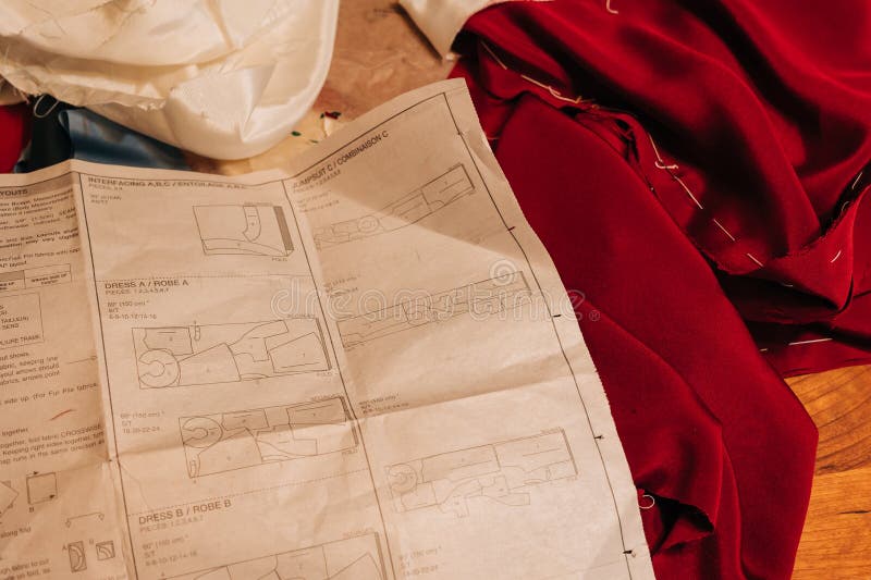Sewing Project in Progress with Pattern Instructions and Red Fabric on a Wooden Table Stock ...
