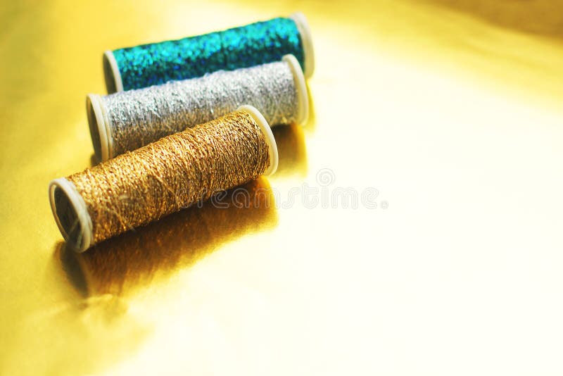 Sewing Threads on a White Background. Bright Shiny Threads. Gold and ...