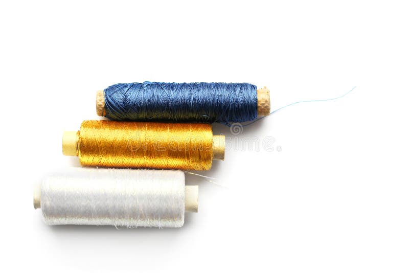 Sewing Threads on a White Background. Bright Shiny Threads. Gold and ...
