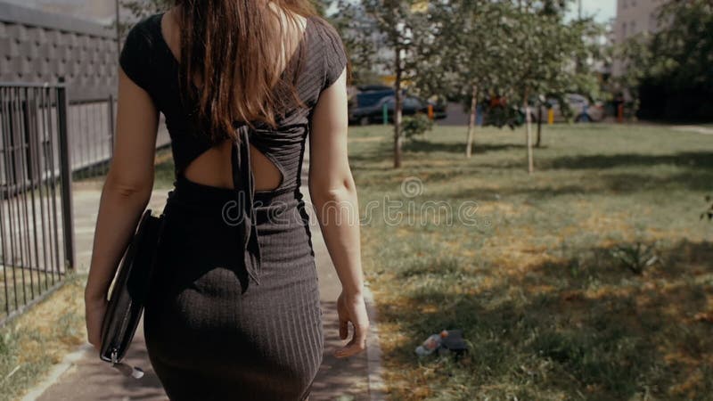Business Woman Walking On A Sidewalk In Urban Street With Her Briefcase