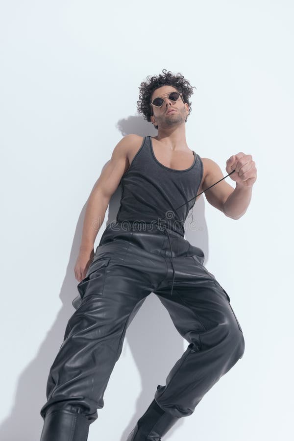 Fit Guy in Leather Pants and Undershirt Laying on a Grey Wall Stock ...