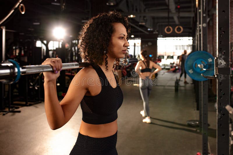 Gorgeous African American Woman Working Out With A Barbell In The Gym