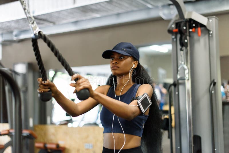 Gorgeous African American Woman Working Out At The Gym And Listens To