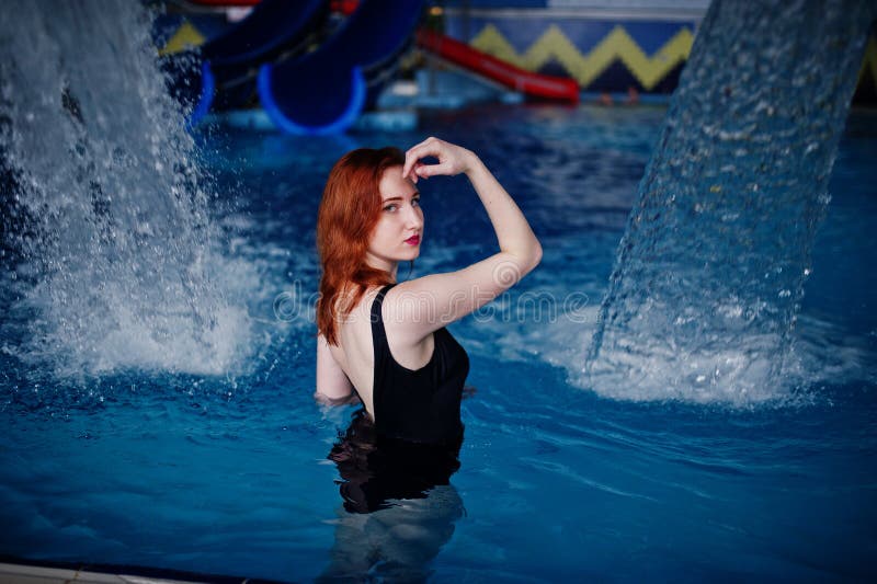 Red Haired Girl In Black Swimsuit Having Rest In Swimming Pool Of Aqua