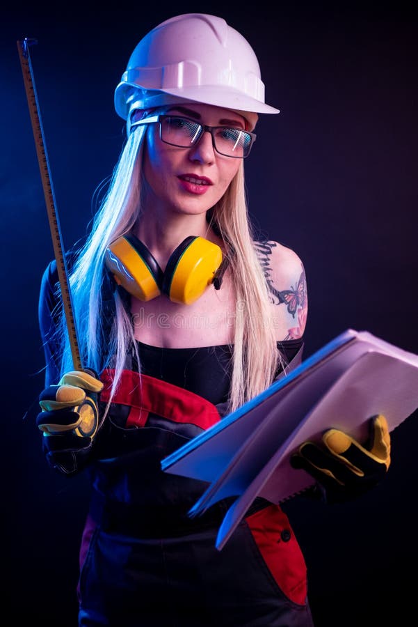 Woman Architect Holding Blueprints and Wearing a Helmet. in the Neon ... Woman Architect Holding Blueprints and Wearing a Helmet. in the Neon ...