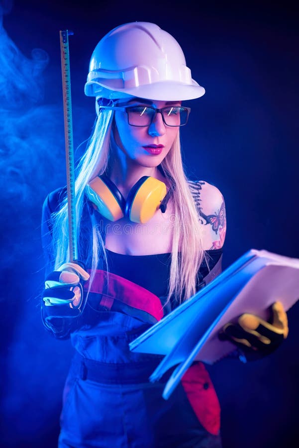 Woman Architect Holding Blueprints and Wearing a Helmet. in the Neon ... Woman Architect Holding Blueprints and Wearing a Helmet. in the Neon ...