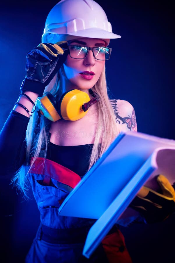 Woman Architect Holding Blueprints and Wearing a Helmet. in the Neon ... Woman Architect Holding Blueprints and Wearing a Helmet. in the Neon ...