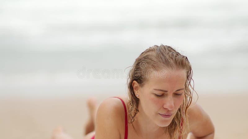 Woman In A Bikini Relaxes On A Sandy Beach At The Ocean Stock Video