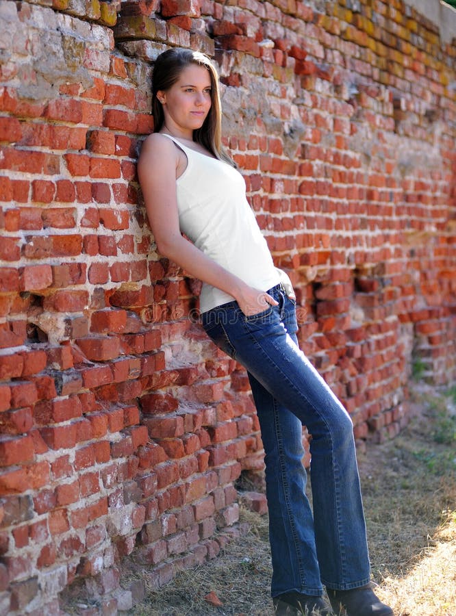 Young Woman Against a Brick Wall Stock Image - Image of sultry, denim ...