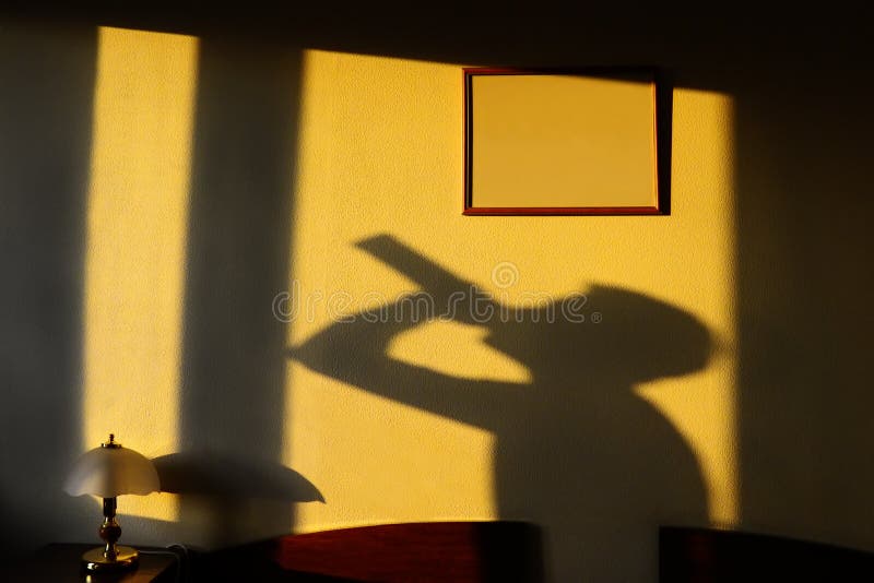 Shadow of the Alcoholic Drinking from a Bottle on a Yellow Wall from a ...