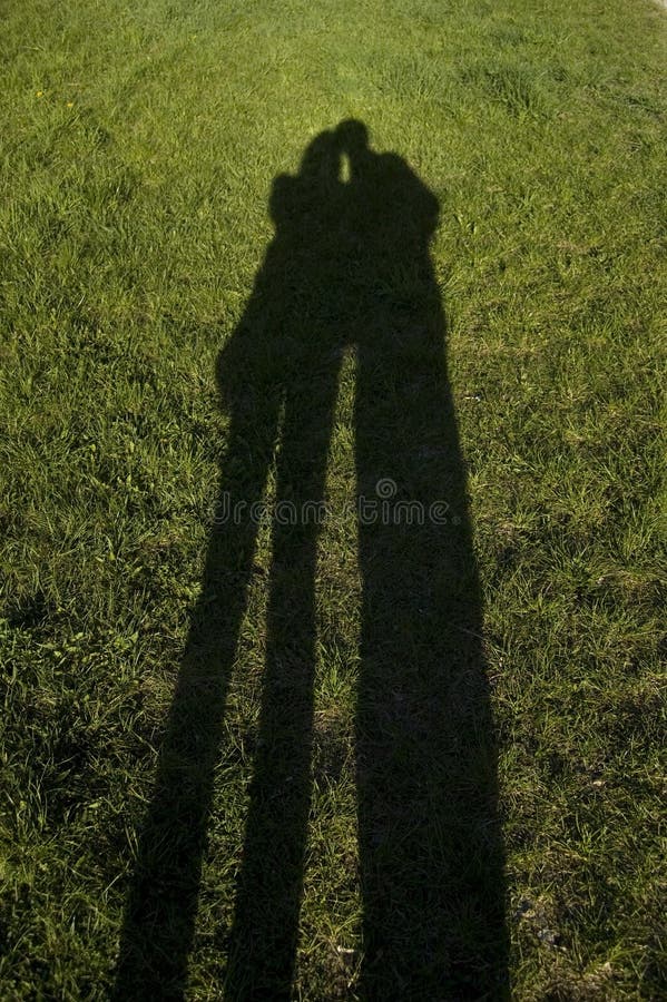 Shadow of couple on grass stock photo. Image of vertical - 239336900
