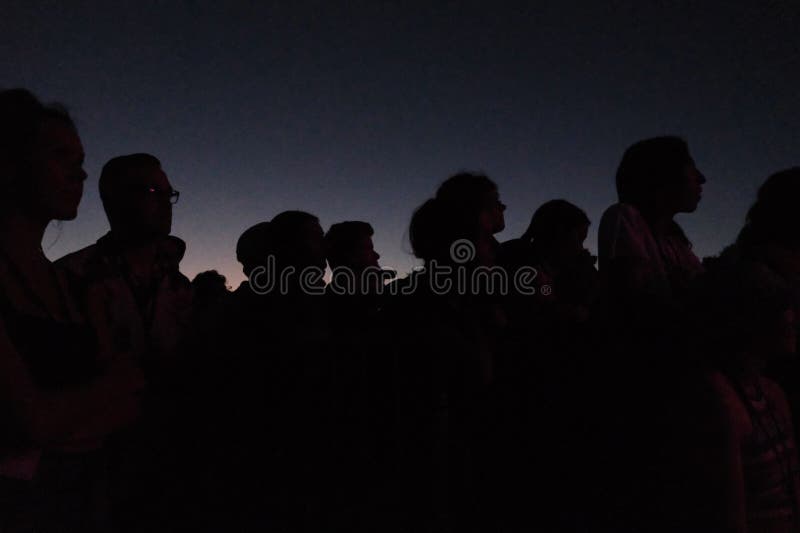 A Crowd of People in Silhouette Against a Darkening Sky. Stock Photo ...
