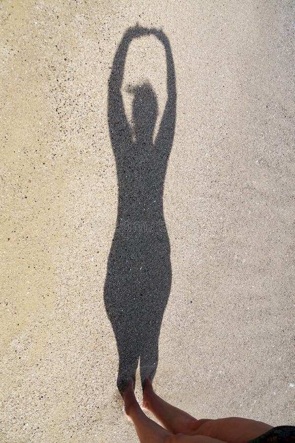 Shadow of a Female Figure with Raised Hands on the Sand Stock Photo ...