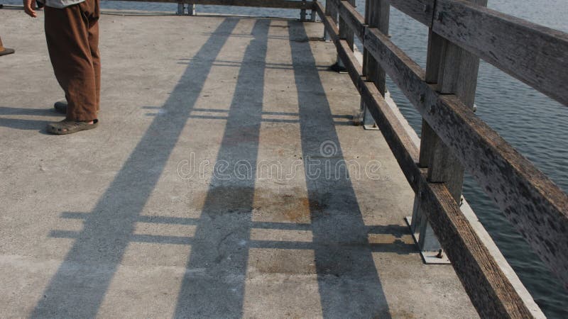 The Shadow of a Fence on the Edge of the Ocean and Accompanied by Human ...