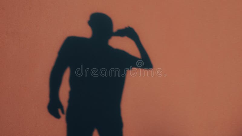 Shadow Figure. a Man Drinks Alcohol from a Bottle. Back View of Shadow ...