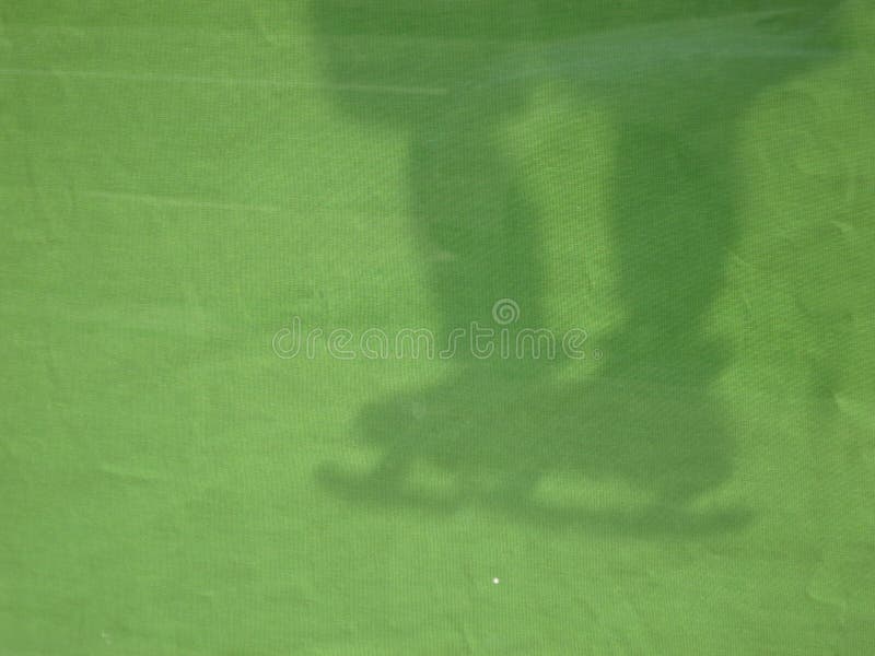 Shadow on Green Canvas of Two Legs with Skates on Its Feet Stock Photo ...