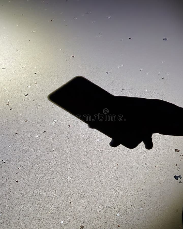 Shadow of a Hand Holding Mobile Phone on the Beach Sand Stock Photo ...