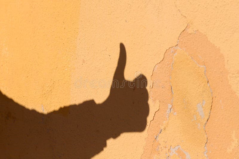 Shadow of a Hand with a Thumb Up on the Background of an Old Yellow ...