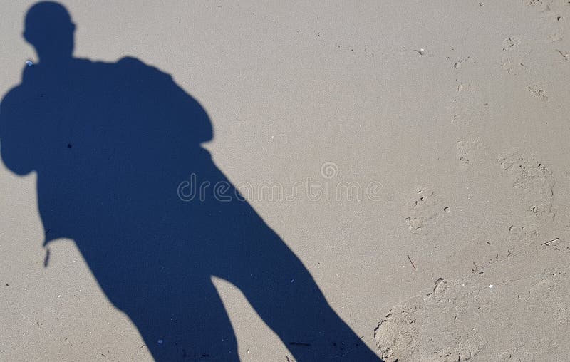 Shadow of a Man Standing on the Beach with His Shadow on the Sand Stock ...