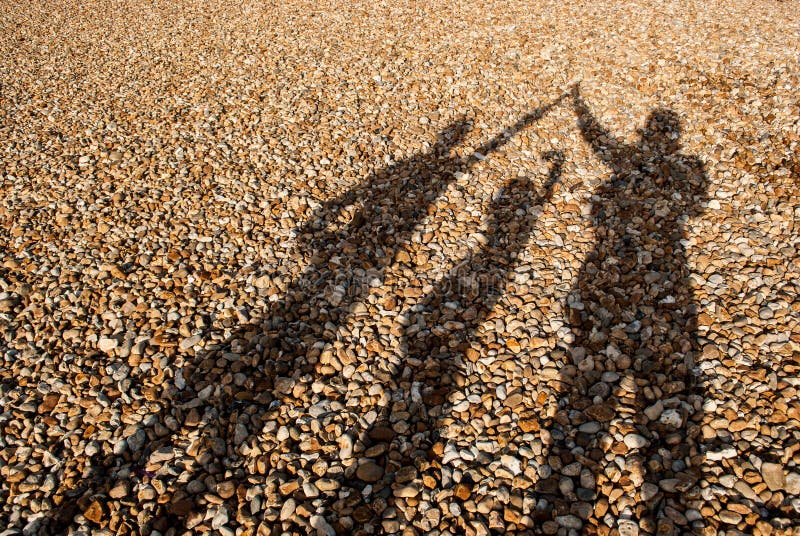 Shadow of 3 People on Pebble Beach Stock Image - Image of granite ...