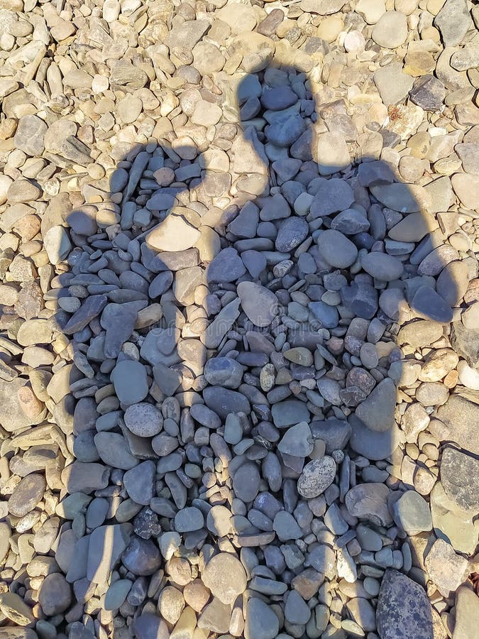 Shadow of People from the Sun on Pebbles Stock Image - Image of shadow ...