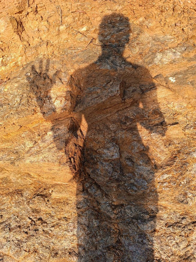 Shadow of Person Making Five Sign on Rocks at Sunset Stock Photo ...