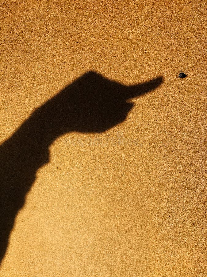 Shadow of a Pointing Hand on Golden Sandy Beach Surface Stock Image ...