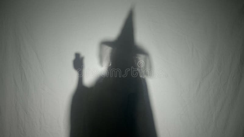 Shadow Silhouette of an Evil Witch Dialing a Phone Number Laughing and ...