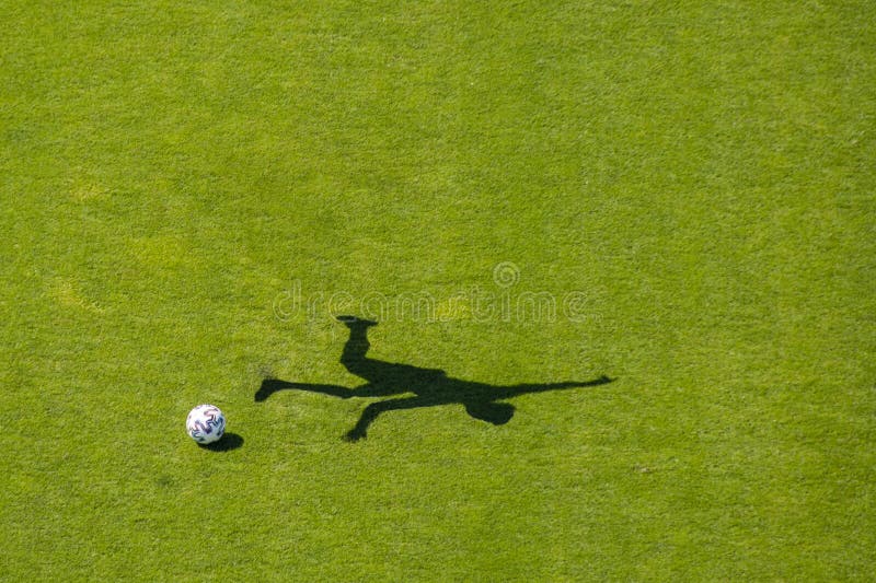 Shadow of a Soccer Player with a Ball on the Grass of a Soccer Field ...