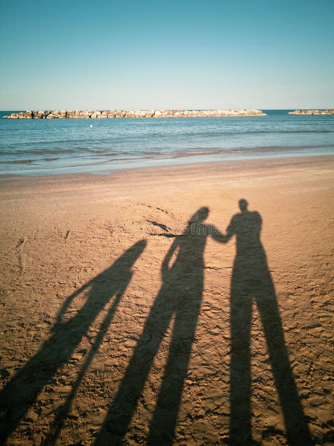 Shadow of Three People on the Sand of the Beach in Summer Stock Photo ...