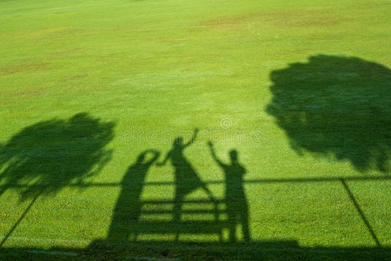Shadow of Three People and Tree in Green Grass Stock Photo - Image of ...
