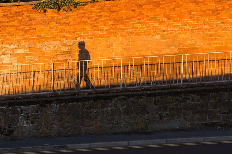 Shadow Walking Down the Slope Against a Red Brick Wall Stock Photo ...
