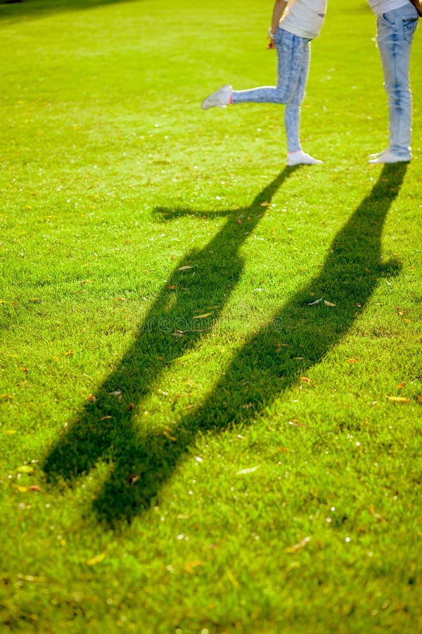 The Shadow of a Young Couple on the Grass Stock Photo - Image of ...