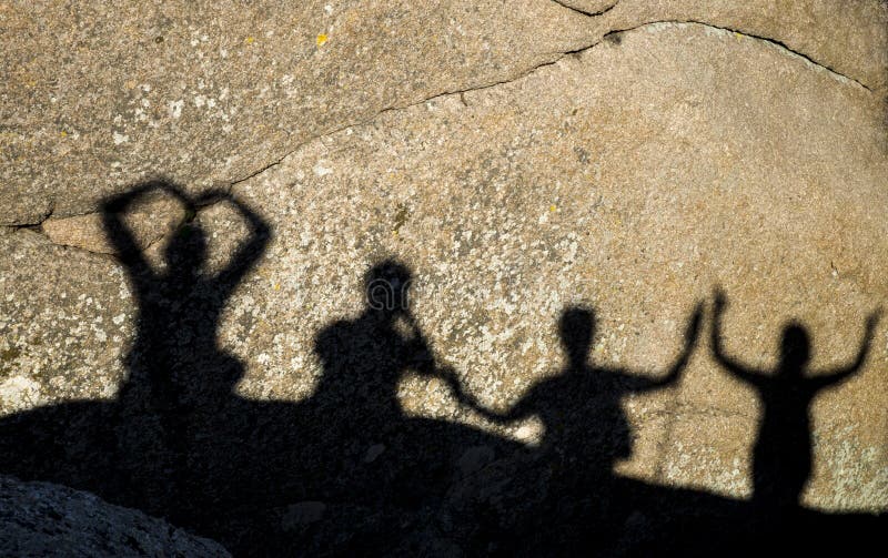 Shadows of Happy People with Arms Raised on Rock Stock Image - Image of ...