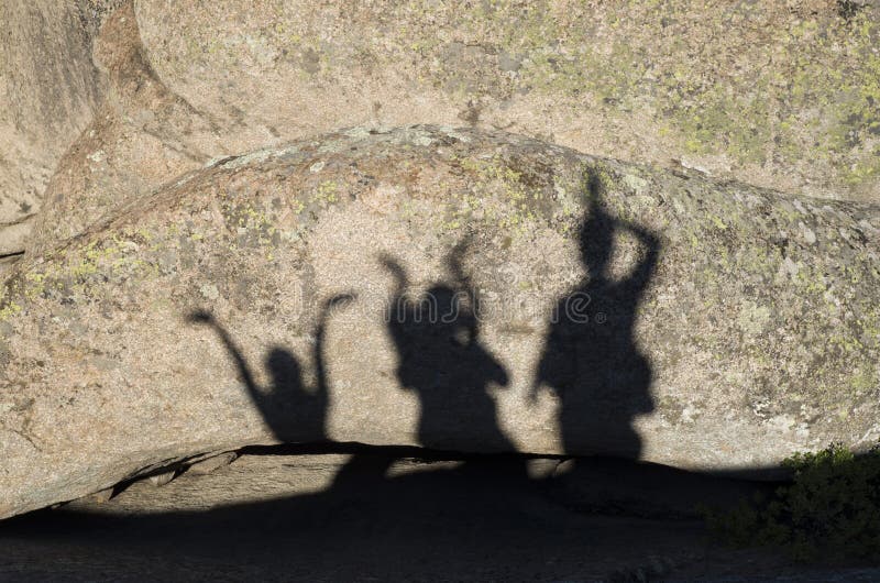 Shadows of Happy People with Arms Raised on Rock Stock Photo - Image of ...