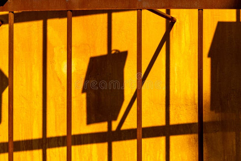Shadows of Mailboxes Projecting on Yellow Wall Behind Rusty Metal Gate ...