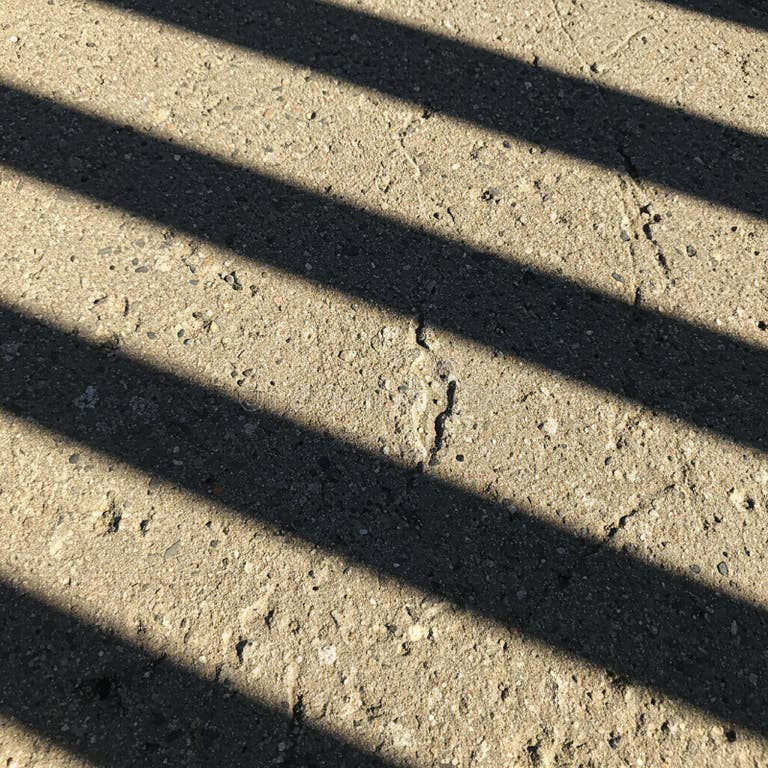 Shadows of Parallel Vertical Lines Fall Across a Textured Concrete ...