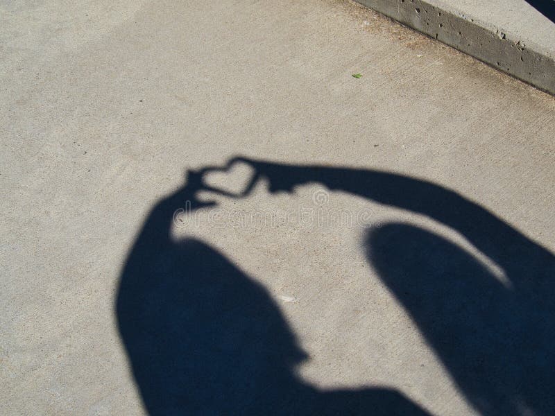 Shadows of Two People Joining Hands To Create a Heart Symbol on the ...