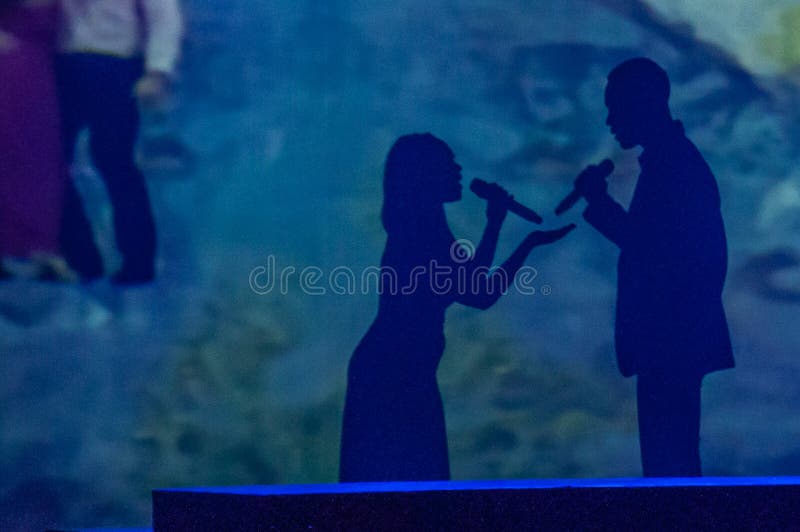 Shadows of Two People Singing Projected on a Wall Stock Image - Image ...