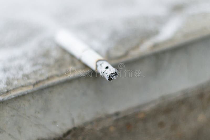 . Shallow Depth of Field. Cigarette Smoldering Lies on the Concrete ...