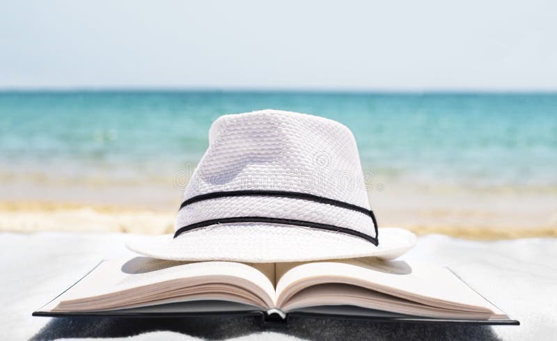 Shallow Focus Shot of a White Hat on an Open Book in the Beach Stock ...
