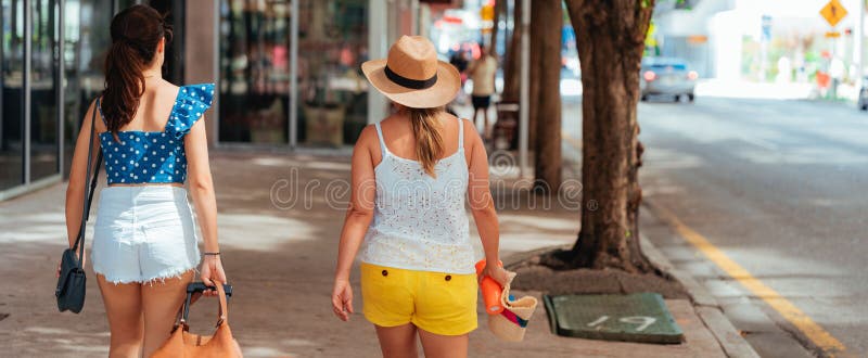Shallow Focus Of Two Young Women Walking On A Sidewalk On A Hot Day Stock Image Image Of