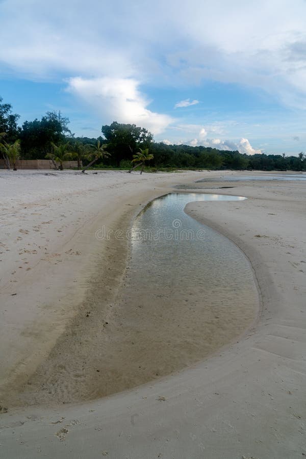 A Shallow Puddle Forms on the Beach, Nestled between Ripples of Wet ...